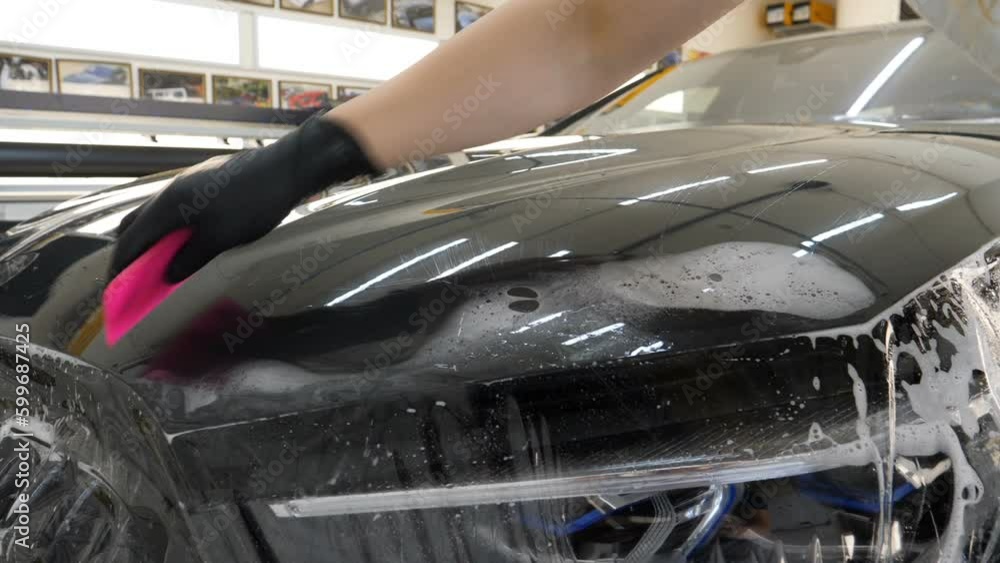 Close up to PPF installation process on a front headlight and hood. PPF ...