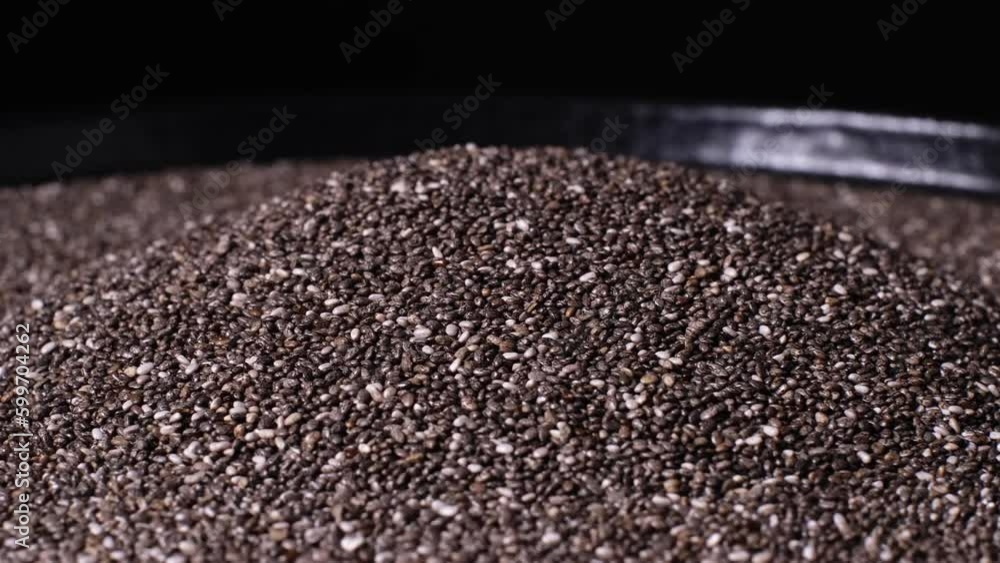 Slow motion of beautiful natural dried chia seeds rotating on a plate ...
