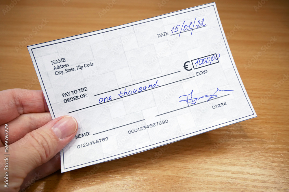 Hand holds a bank check on wooden table background, Blank bank cheque ...