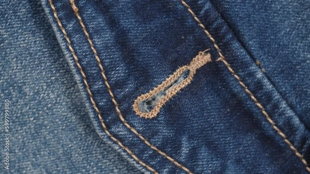 clasp loop on the pocket of blue jeans. the rotation of the fabric of ...