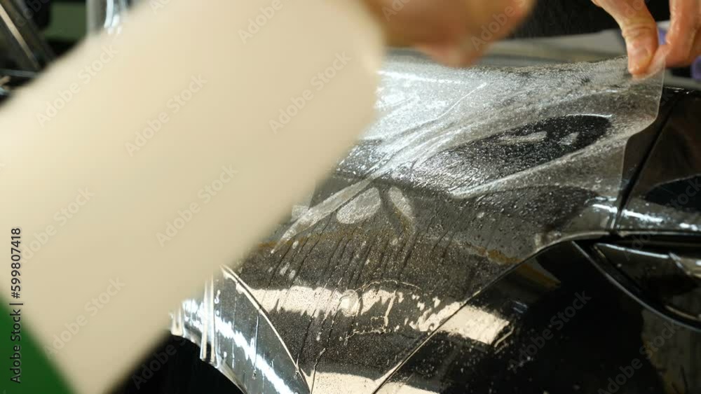 Close up to PPF installation process on a front headlight and hood. PPF ...