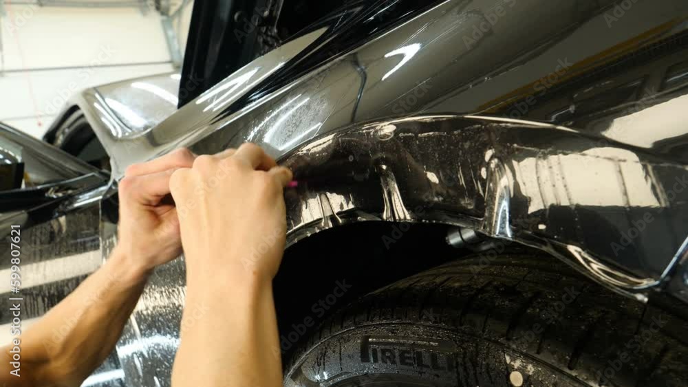 Wideo Stock: Close up to PPF installation process on a front headlight ...