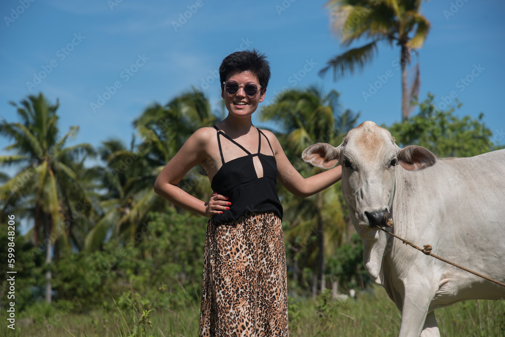 Happy female smiling and having fun with cow on the farm. Woman wears ...