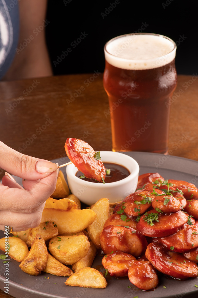 woman's hand picking up a sausage from a portion of bock sausages with ...