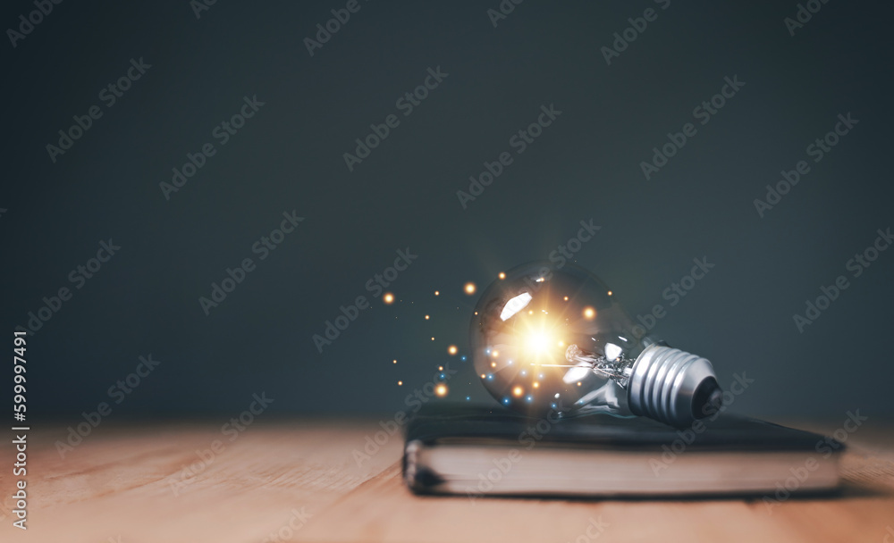 Glowing light bulb on a cover of book, Educational knowledge and ...