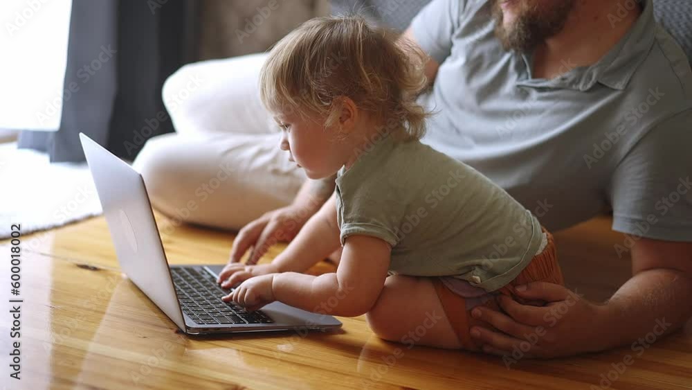 Cute caucasian baby boy is playing with laptop, typing on keyboard and ...