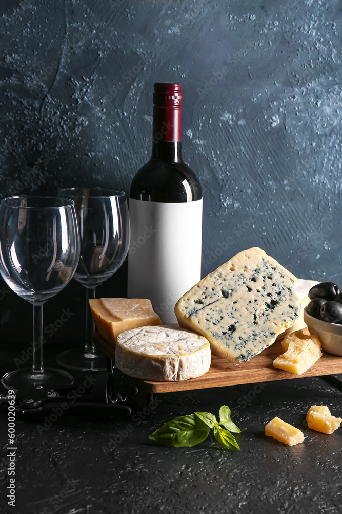 Different types of tasty cheese, glasses and bottle with wine on table ...