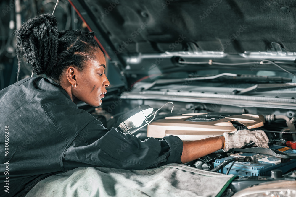 Experienced auto mechanics inspect car battery terminals and voltage to ...