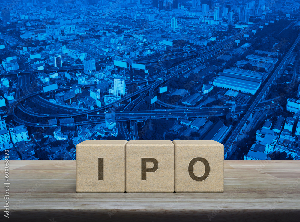 IPO letter on wood block cubes on wooden table over modern city tower ...