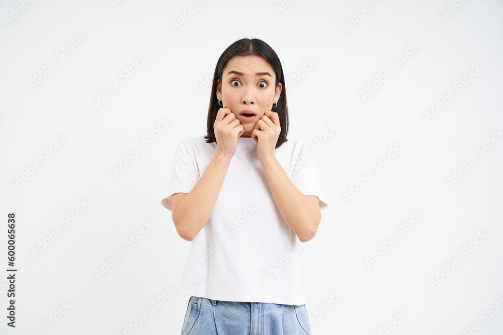 Portrait of shocked, scared asian woman, gasping and jumping scared ...