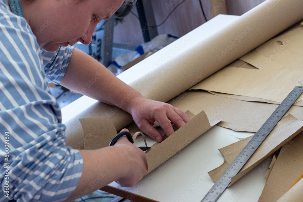 Professional seamstress creates a pattern for clothes in the workshop ...