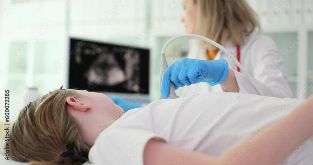 Doctor cardiologist conducting diagnostic examination of heart in child ...