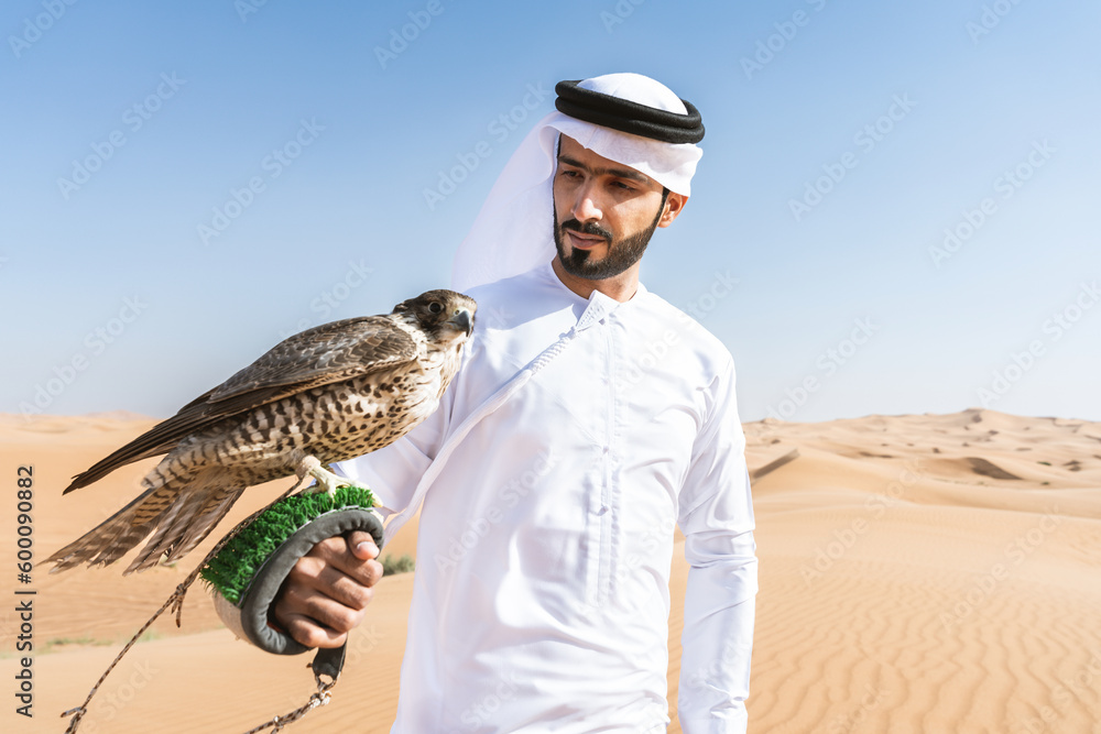 Middle-eastern emirati man wearing arab kandura holding falcon in the ...