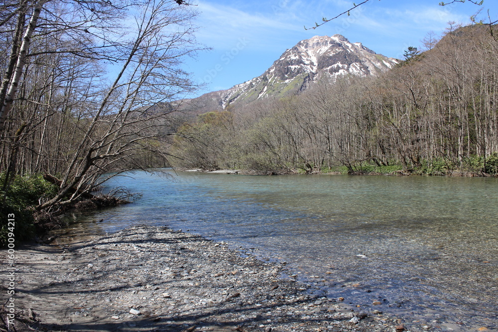 The clear Azusa River and snow-capped Mount Yakedake viewed from ...