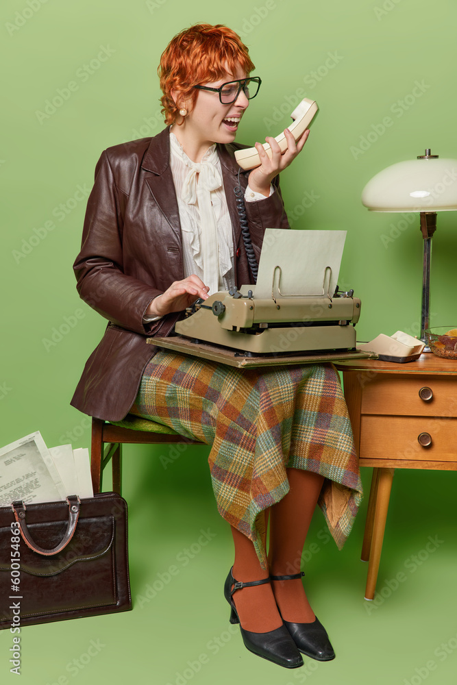 Annoyed redhead female office worker screams angrily holds handset ...