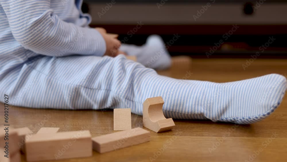 boy kid is playing on floor with woode eco safe block building ...