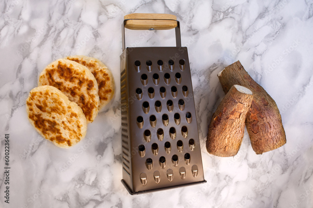 Arepas de Yuca y queso tradicionales ecuatorianas, junto a un rayador y ...