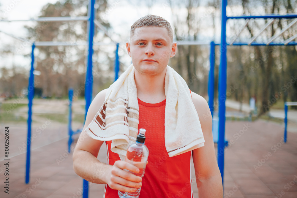 Tired Athlete Recharging with Water Bottle After Training. Sporting guy ...