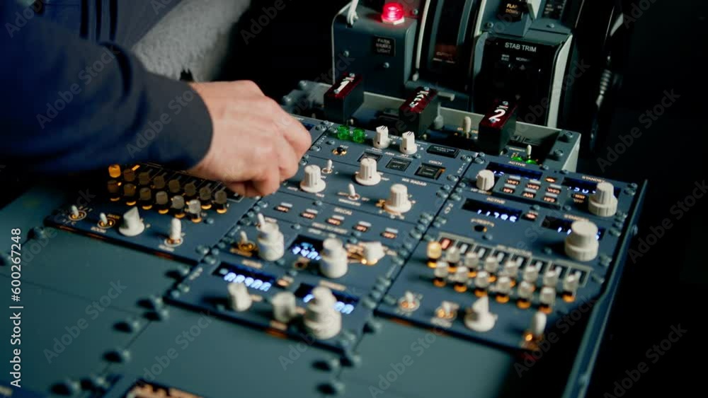 The captain presses the buttons on the control panel to start the ...