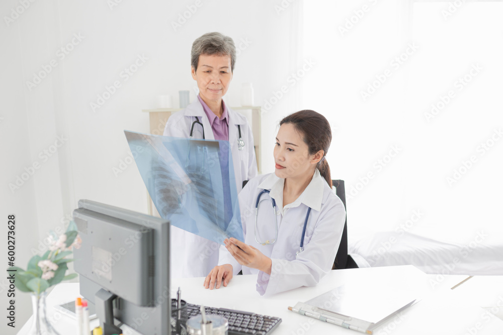 two Asian doctor looking patient film, they talk with treatment plan ...