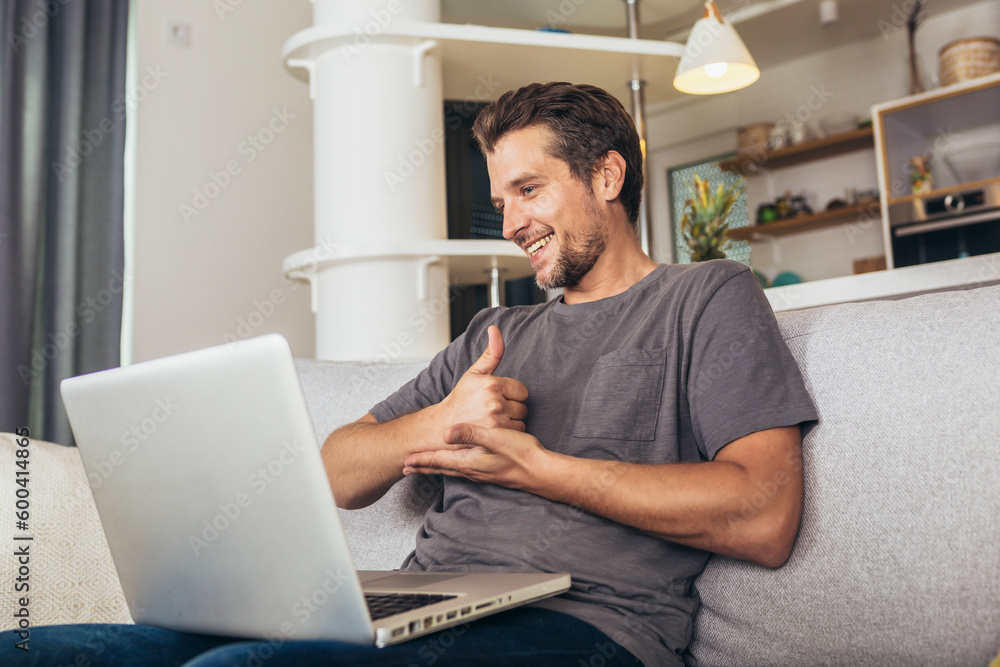 Young man showing gesture in sign language using laptop, make video ...