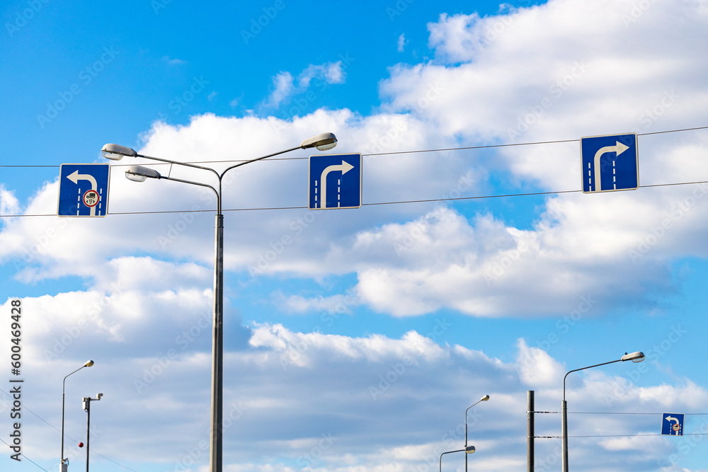 hanging road sign with an arrow indicating the direction of travel ...
