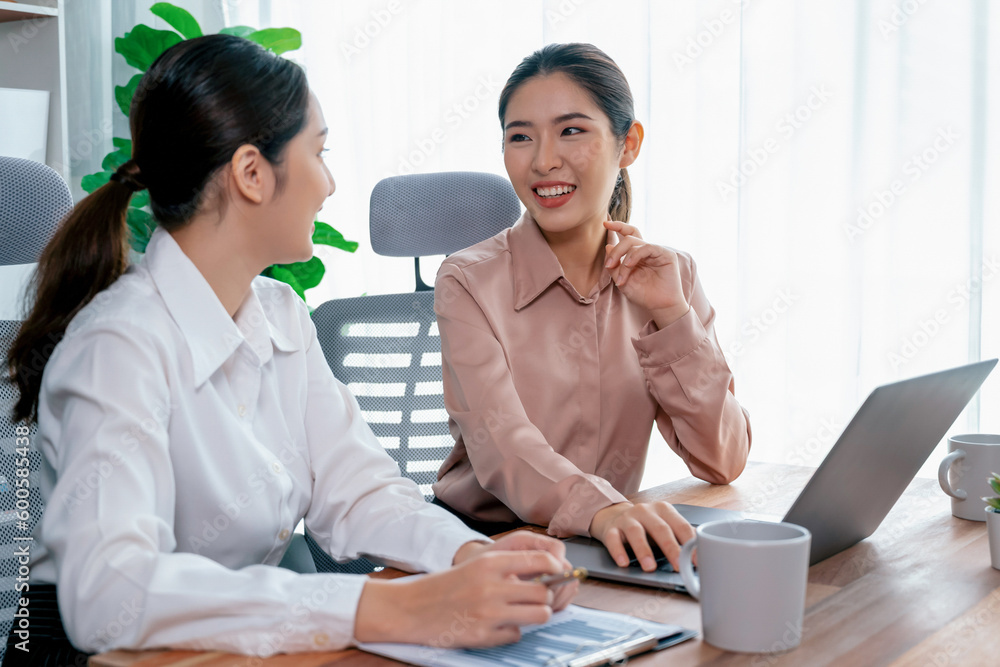 Two young office lady colleagues collaborating in modern office ...