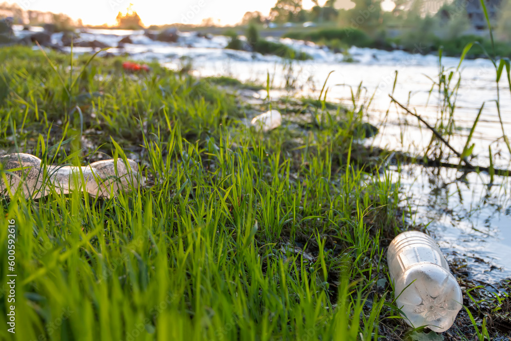 Foto de Plastic bottles, garbage in the polluted green grass on the ...