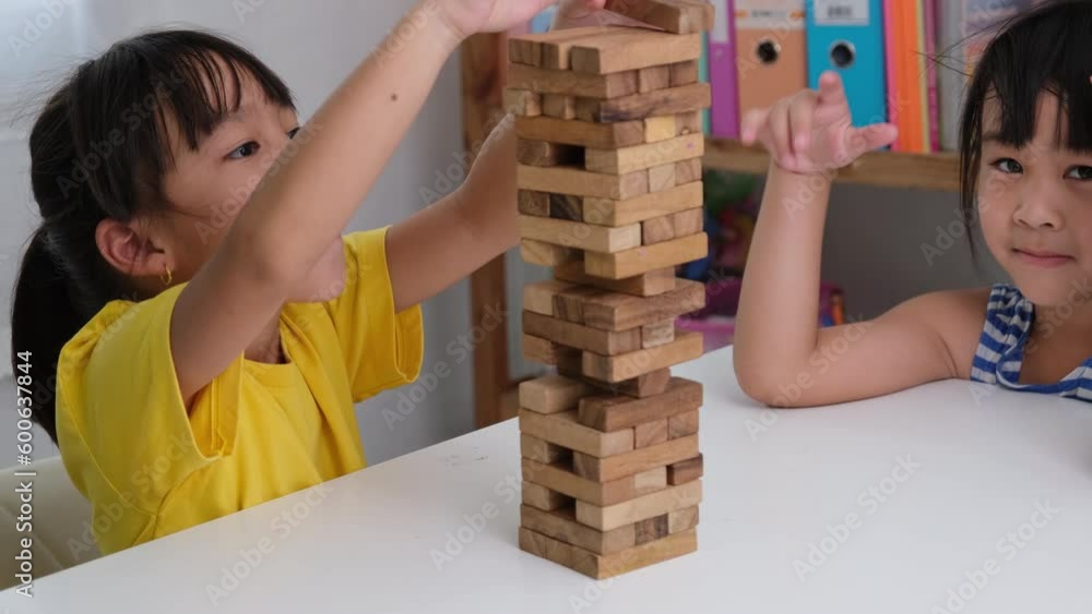 Cute Asian siblings having fun playing Jenga together. Two children ...