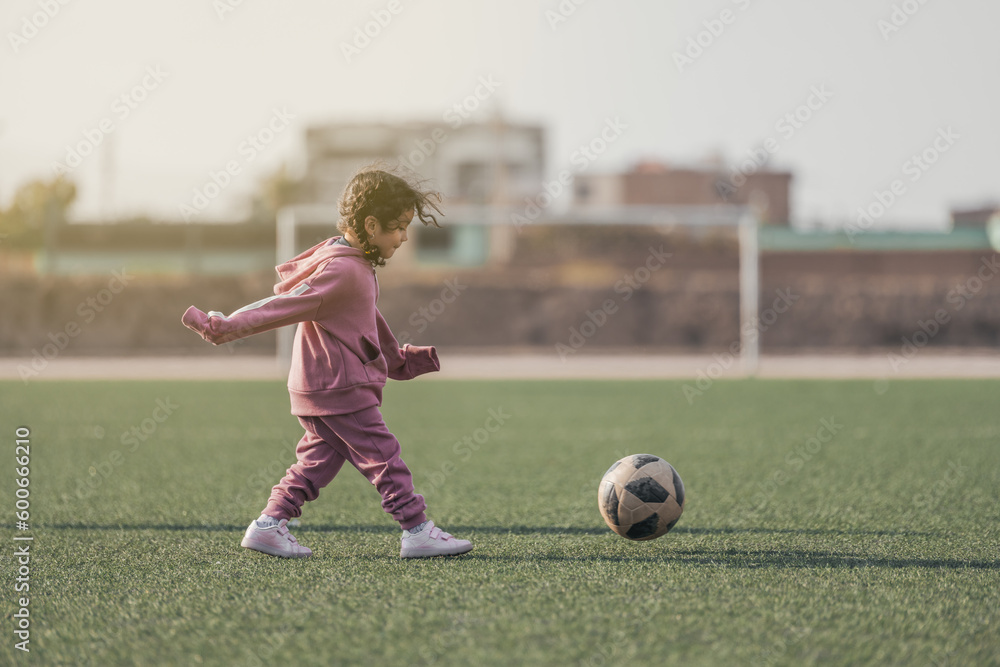 Sports kid. Happy little girl kid kicking a soccer ball, Child plays ...