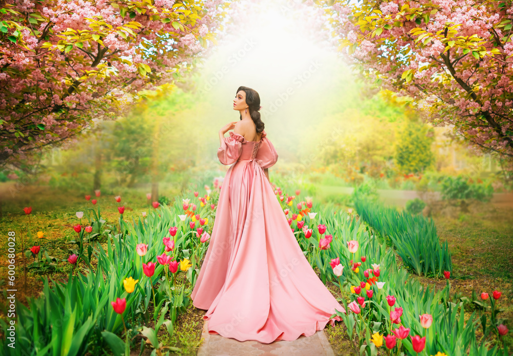 Fantasy girl princess walks in blooming spring garden flowers tulips ...