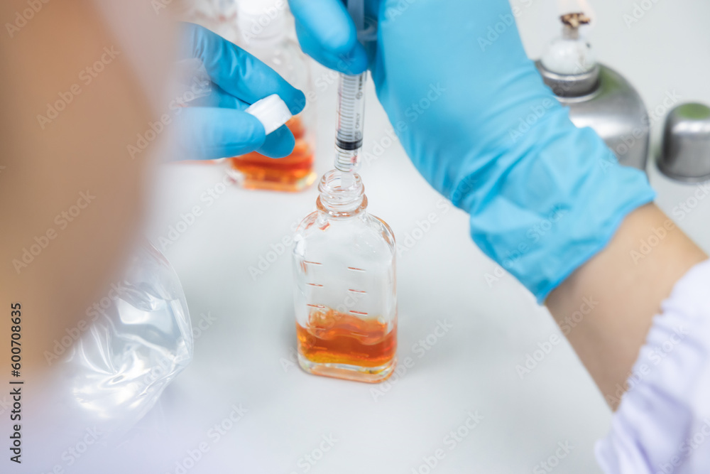 Scientist use syringe contains water dropping to solution bottle for ...