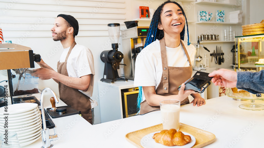 Customer making payment through payment terminal at counter in coffee ...