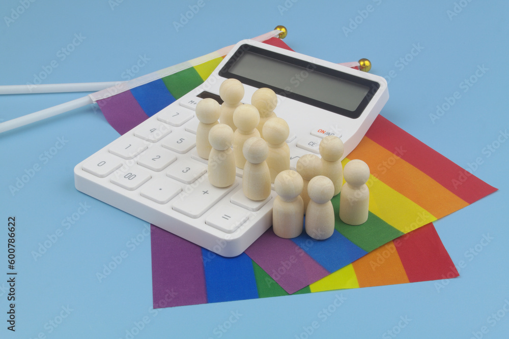 Rainbow LGBT flags with calculator and wooden people figures on blue ...