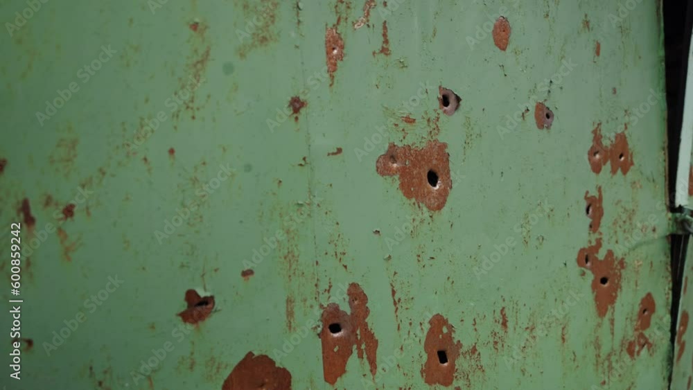 Bullet riddled, metal fence, Damaged surface. It was destroyed by ...