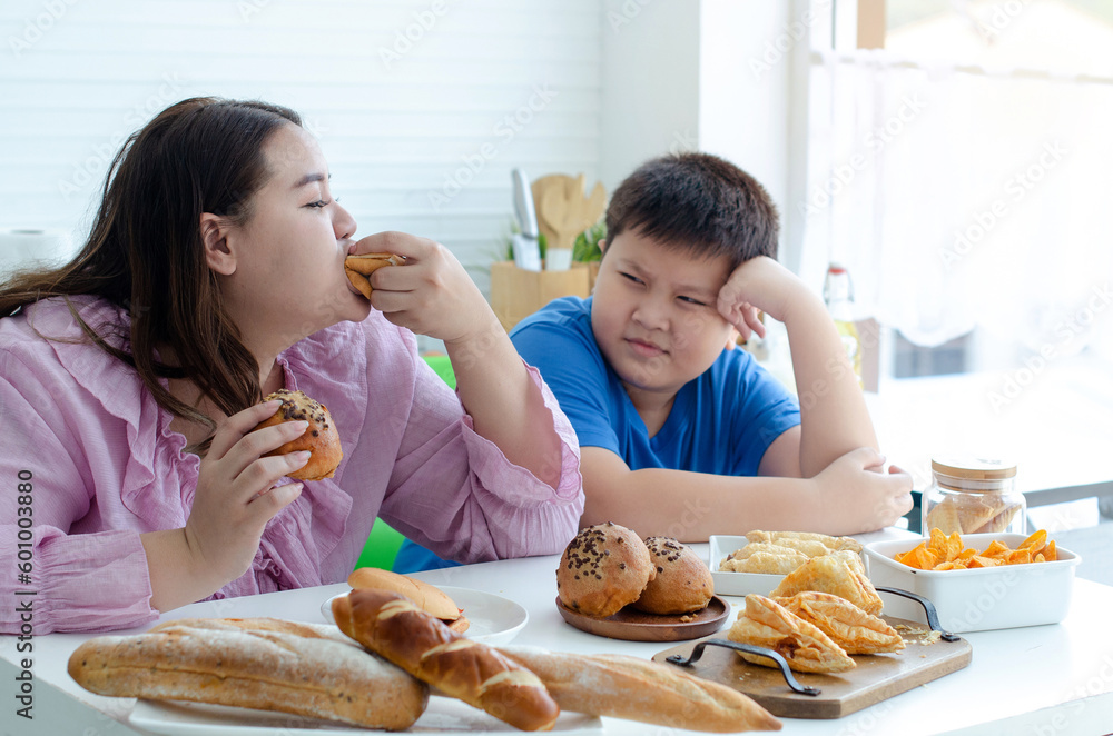 Son watched the fat mother eat too much food, boy looked displeased at ...