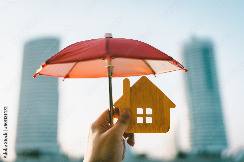 Wooden house model and real estate insurance ideas, individuals holding ...
