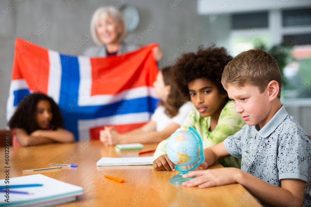 children listen with interest to teacher, who talks about geographical ...