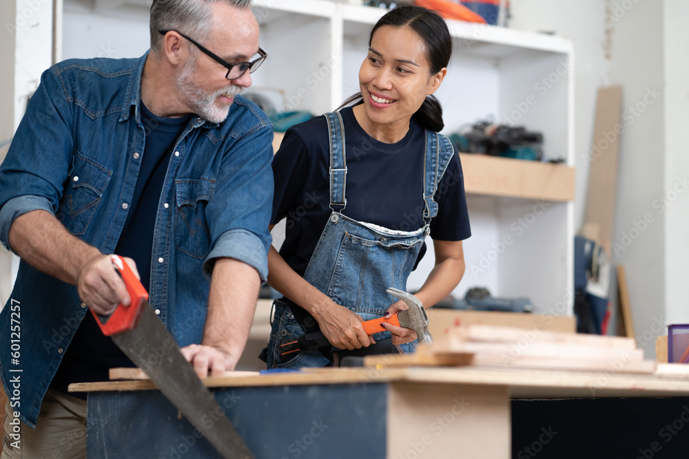 Foto de Happy multicultural couple working together at wood carpenter ...