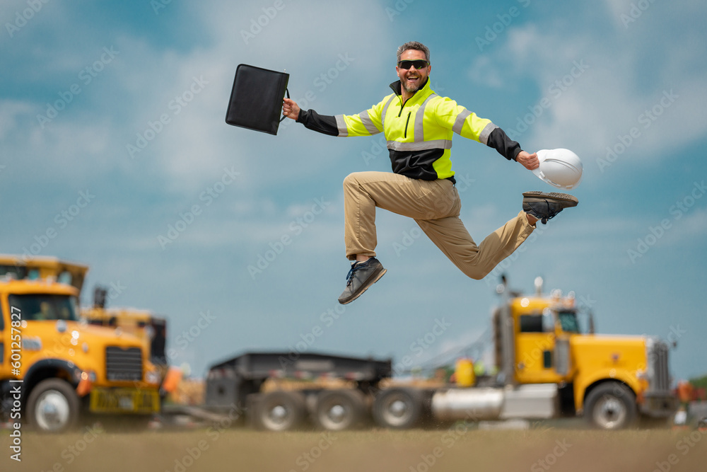 Middle aged builder excited jump on site construction. Excited builder ...