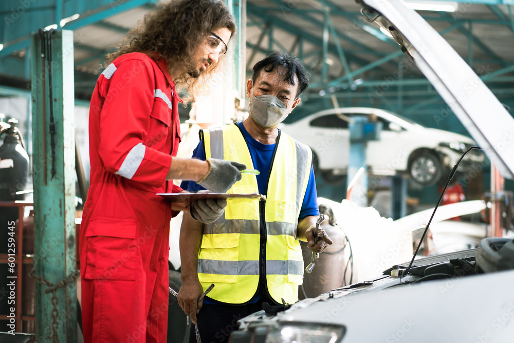 Caucasian auto mechanic checking broken car engine and talking ...