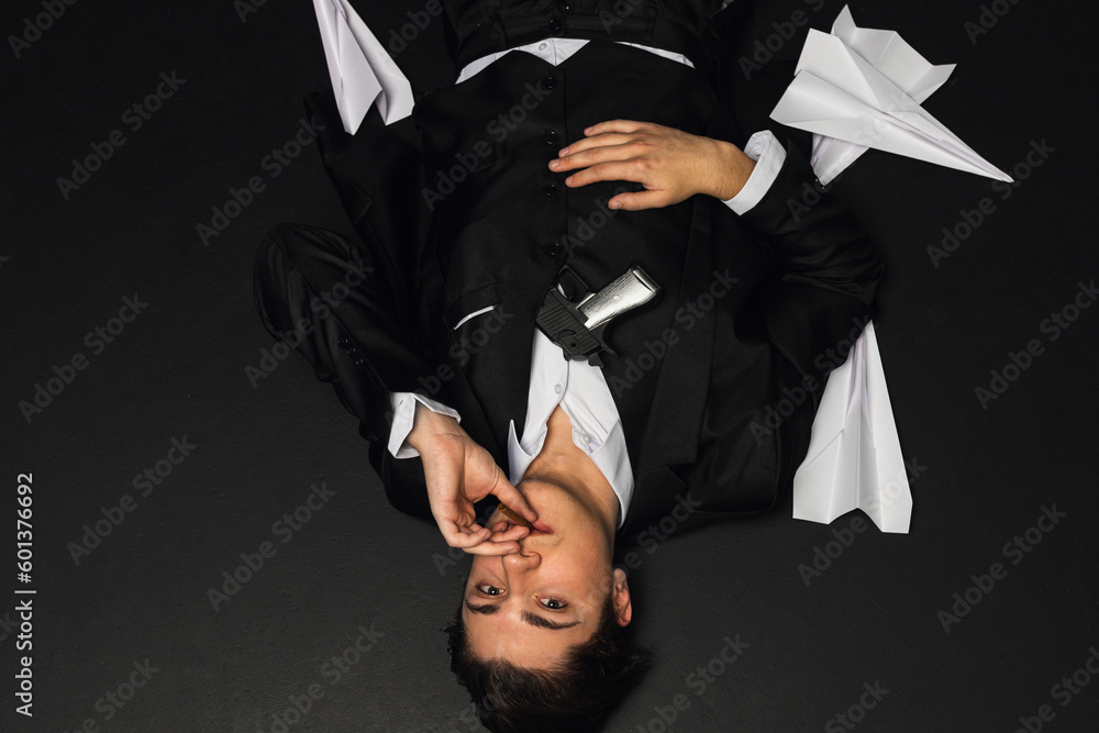 Lying on a floor Young mafia member with a slicked back hair, dressed ...