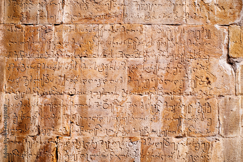The Georgian alphabet is carved on the stone wall of an ancient temple ...
