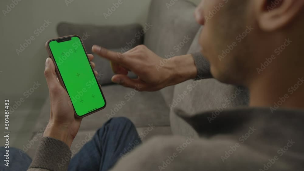 Black Man using Mobile Phone Green Screen Vertically sitting on couch ...