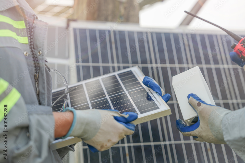 Factory engineers checking and repairing solar panel construction ...