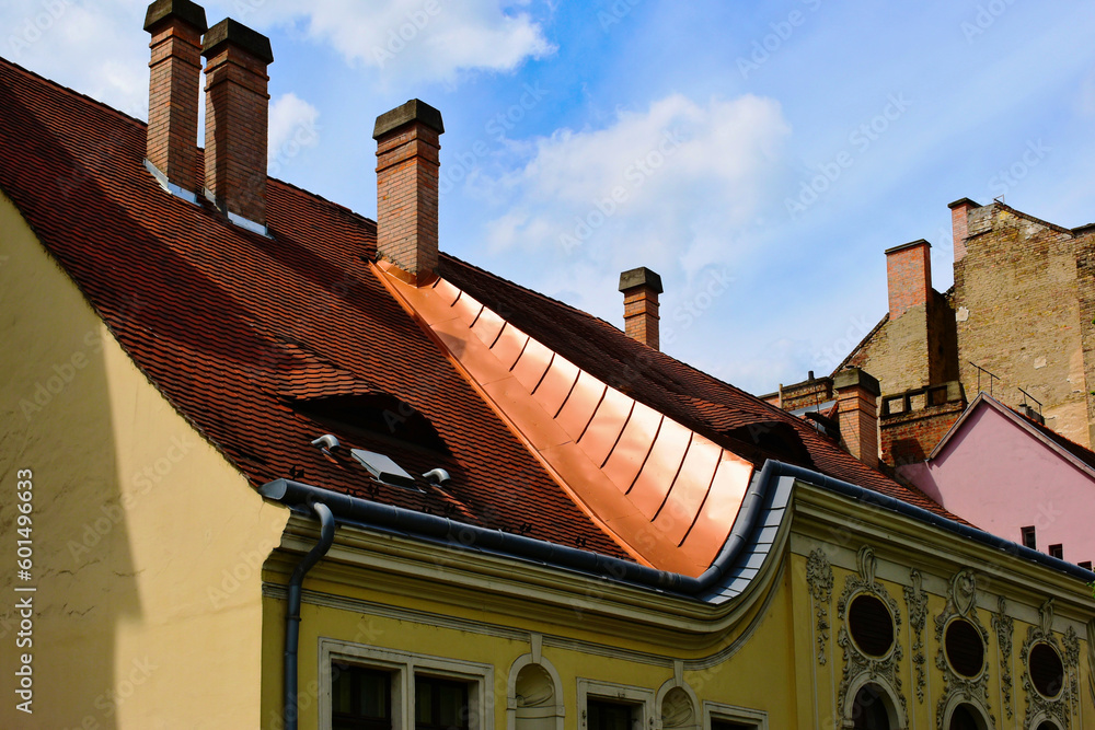 Copper flashing detail on sloped brown clay tile roof and dormer. oval ...