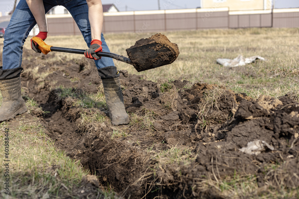 Drainage ditch. A man is digging a ditch. Laying a drainage pipe ...