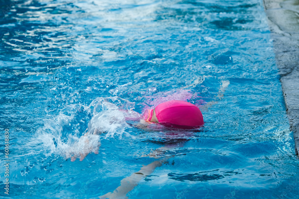 Little girl practicing swimming in the pool. Happy children swimming ...