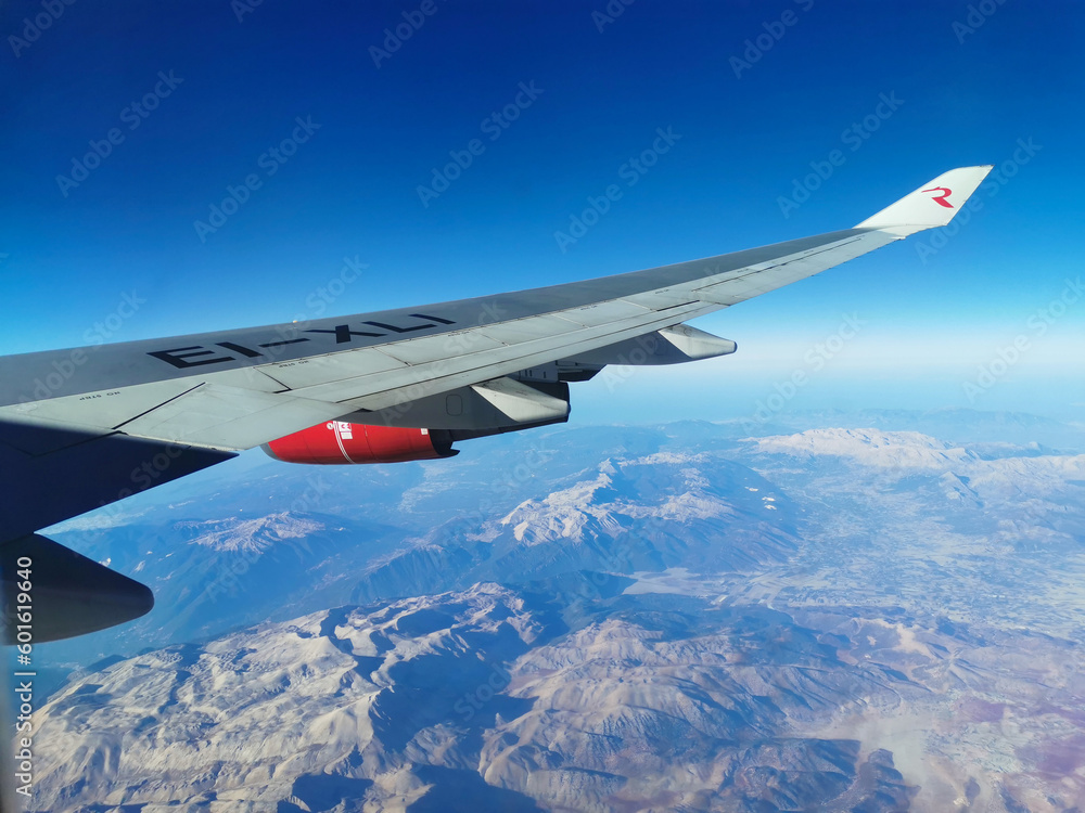 View from the porthole on the wing of an airplane with a red aircraft ...