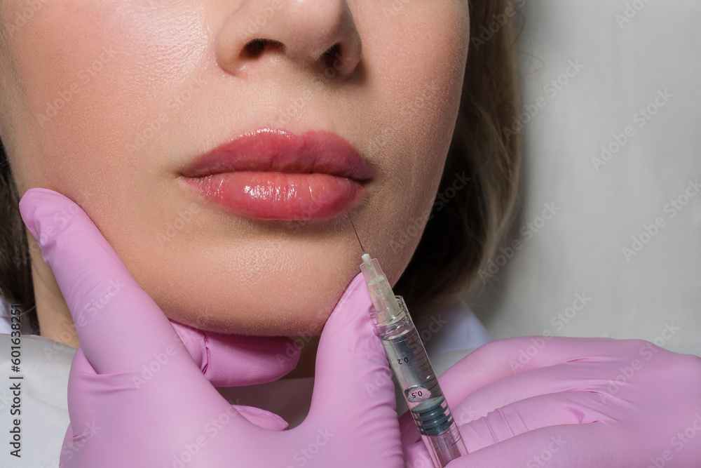 Close up portrait of woman getting botox cosmetic injection in the lips ...